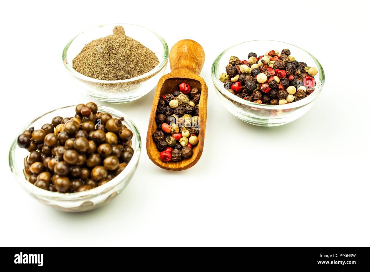 Pepper in wooden spoon. Mix of different peppers balls on white ...