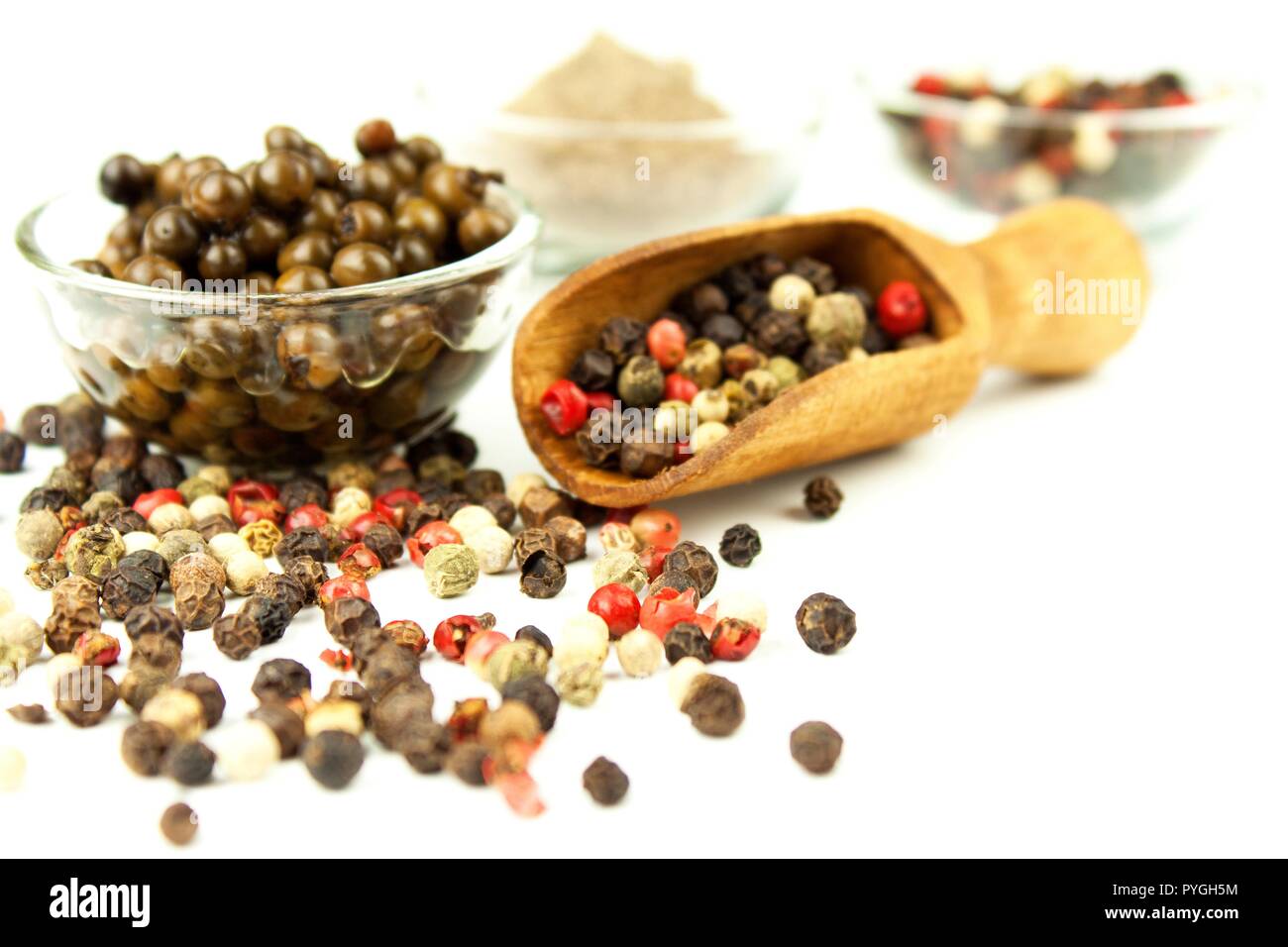 Pepper in wooden spoon. Mix of different peppers balls on white ...