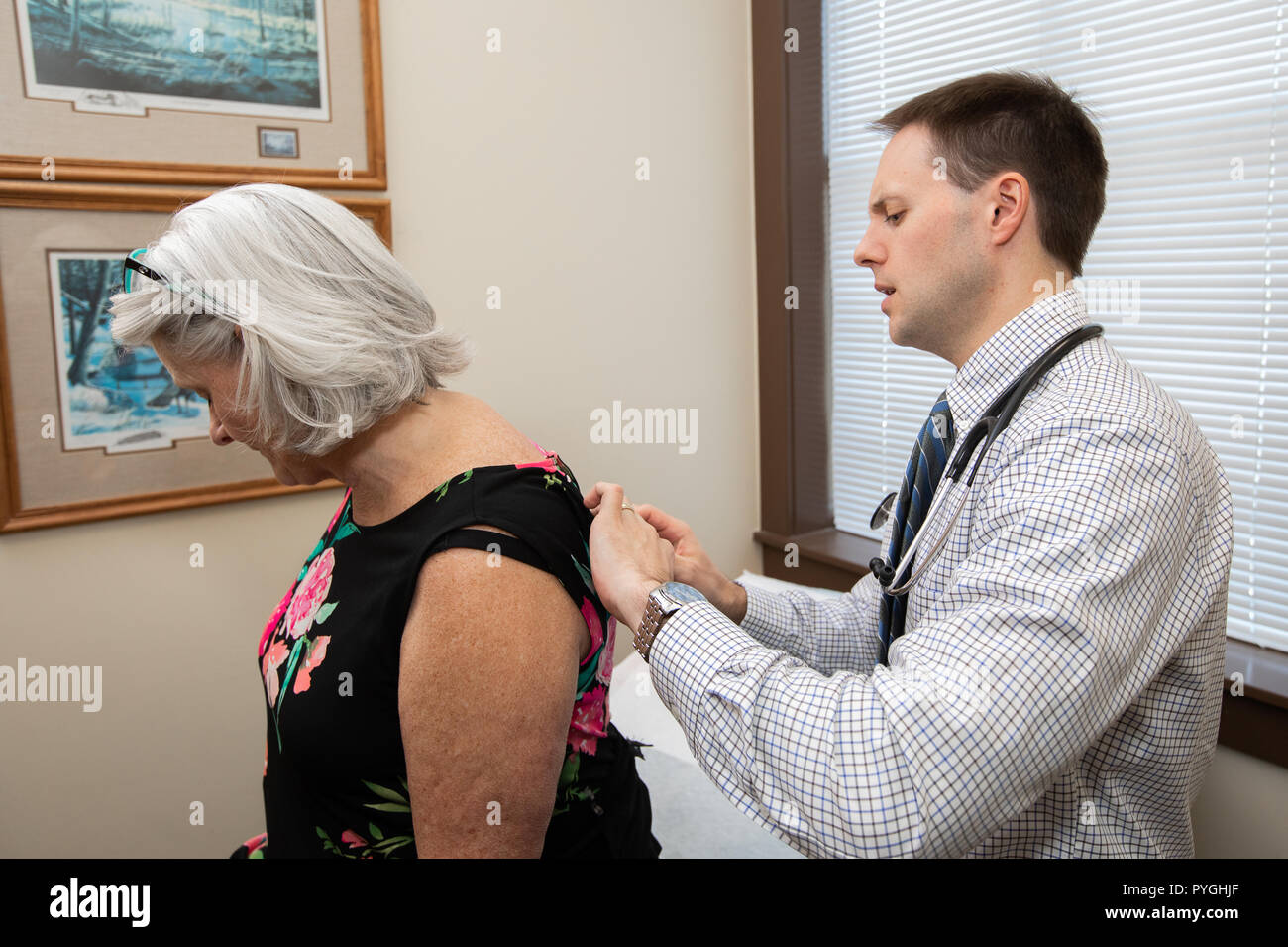 Doctor visits with patient in exam room Stock Photo - Alamy