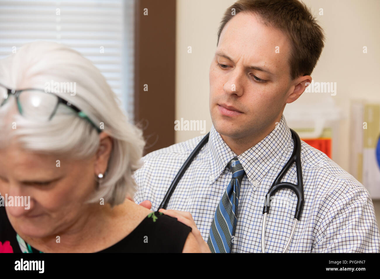 Doctor visits with patient in exam room Stock Photo - Alamy