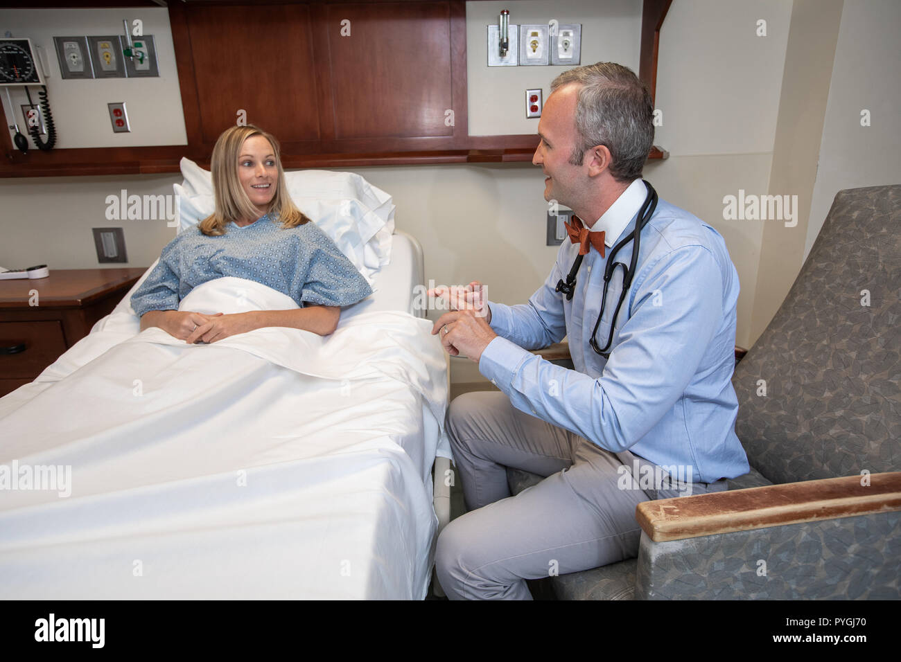 Doctor visits with patient in exam room Stock Photo - Alamy