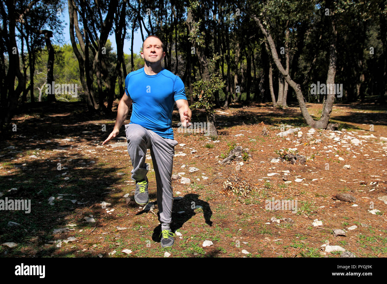 Muscled man doing workout run in place exercise in forest. Handsome ...