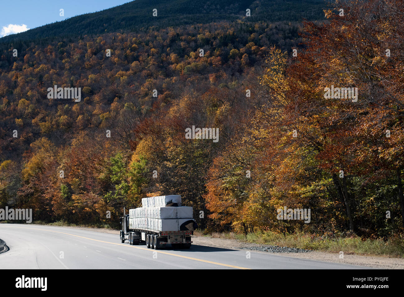 Truck rolling down highway with fall foliage backdrop Stock Photo - Alamy