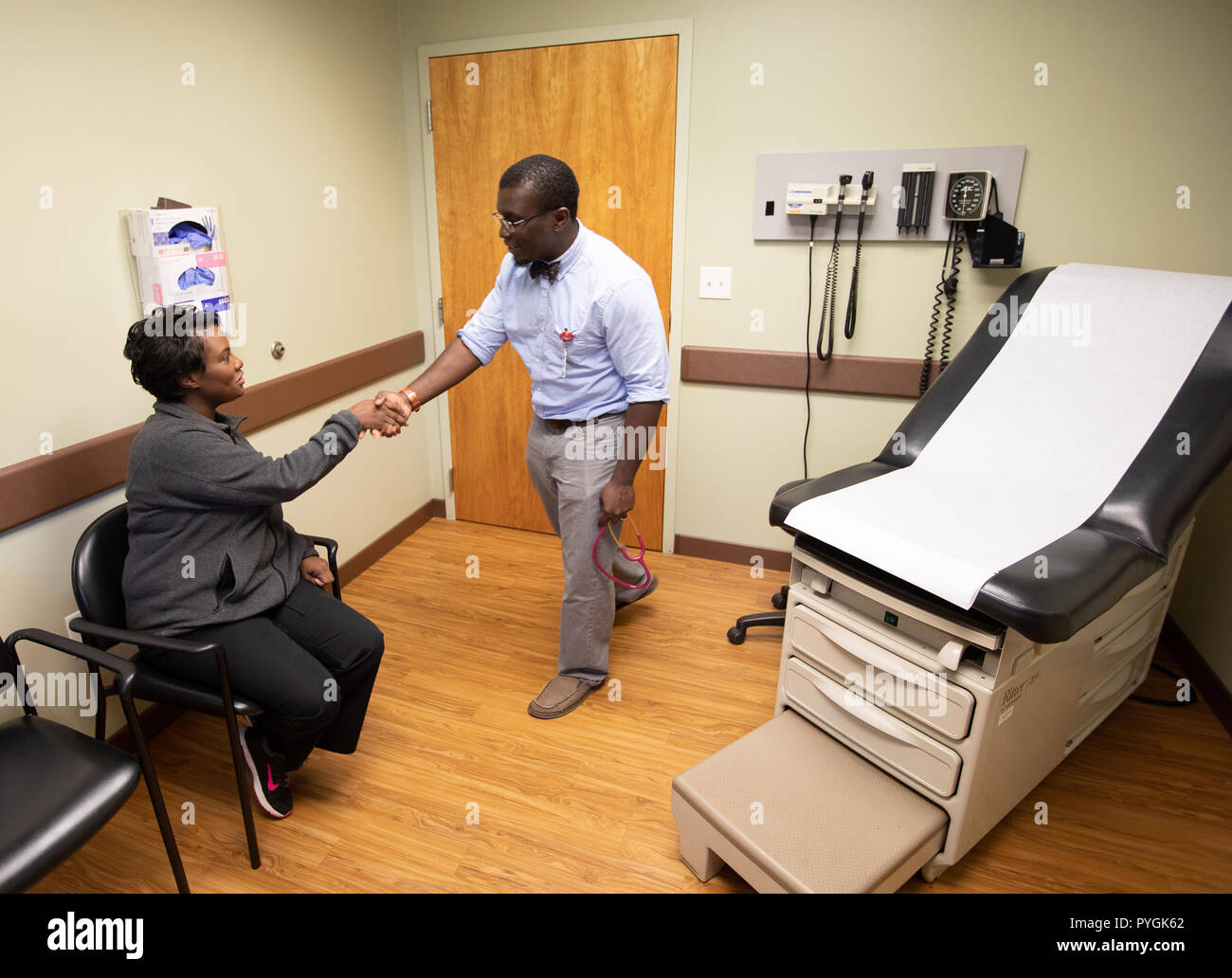 African-American doctor checks patient's heart and lungs with ...