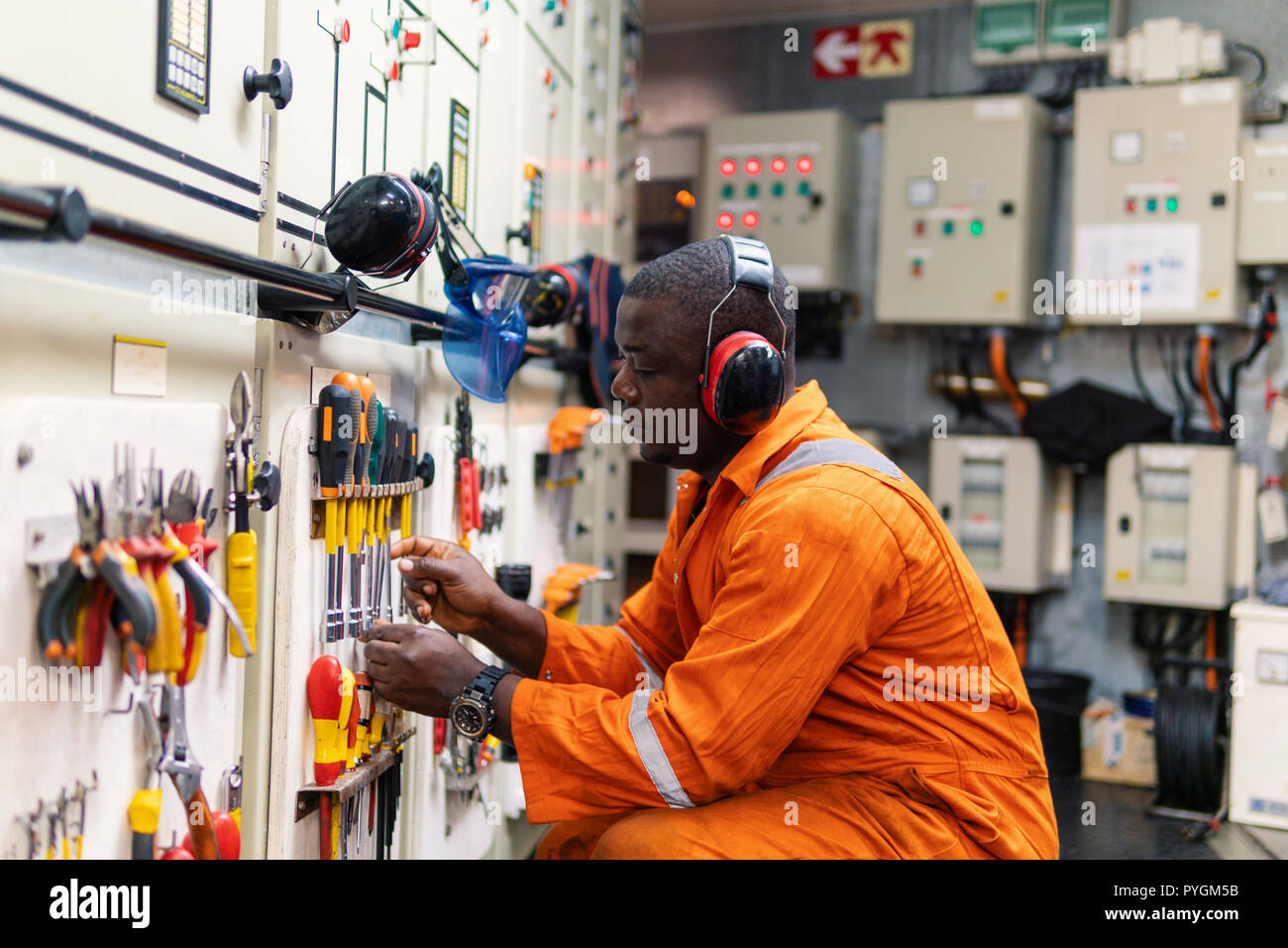 Marine engineer officer working in engine room Stock Photo - Alamy