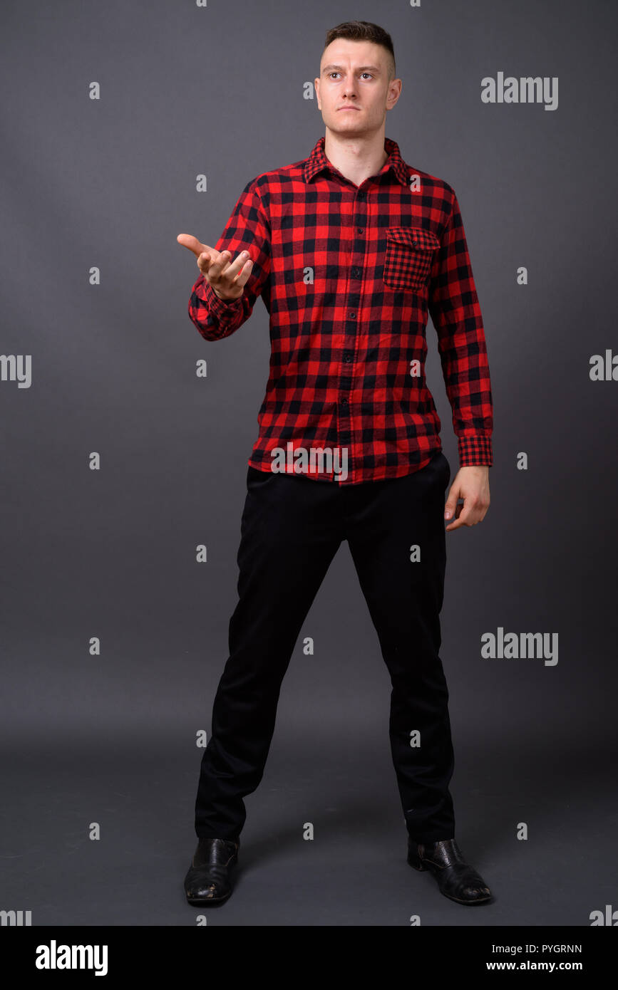 Studio shot of young handsome man with arm raised Stock Photo - Alamy