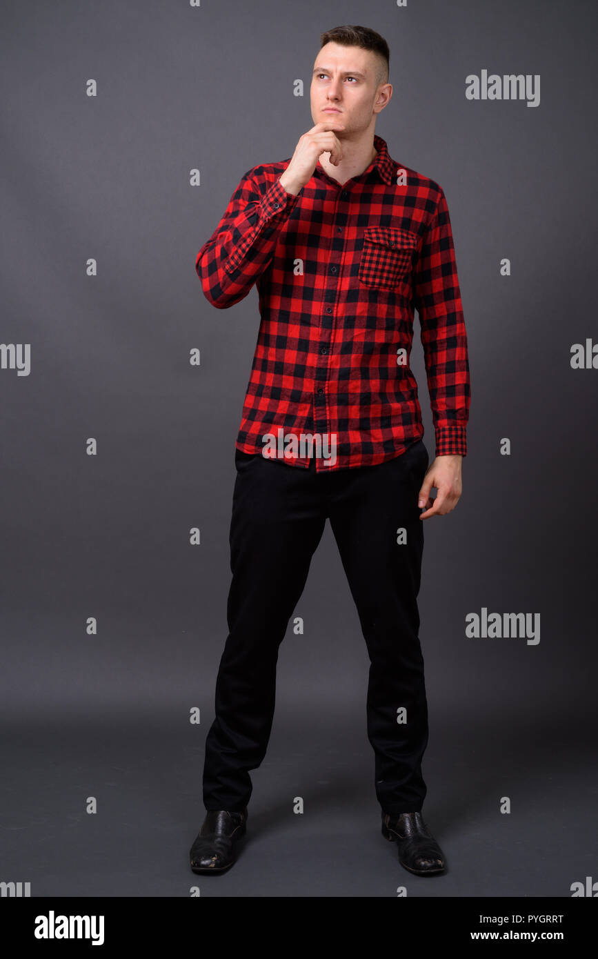 Studio shot of young handsome man thinking Stock Photo - Alamy