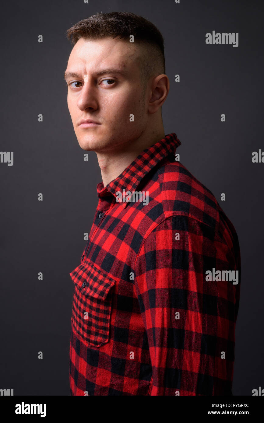 Profile view of young handsome man looking at camera Stock Photo - Alamy
