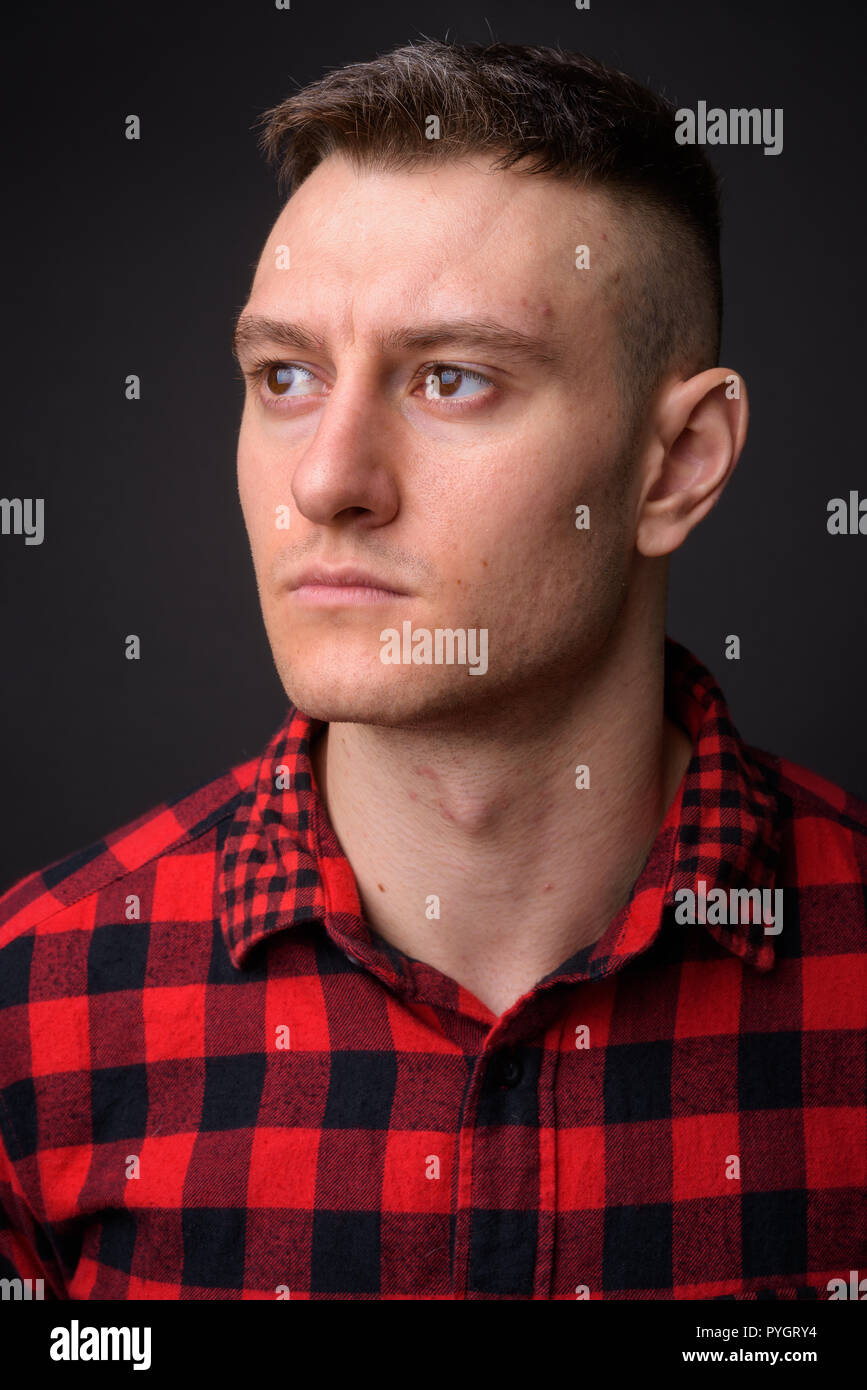 Face of young handsome man thinking against gray background Stock Photo ...