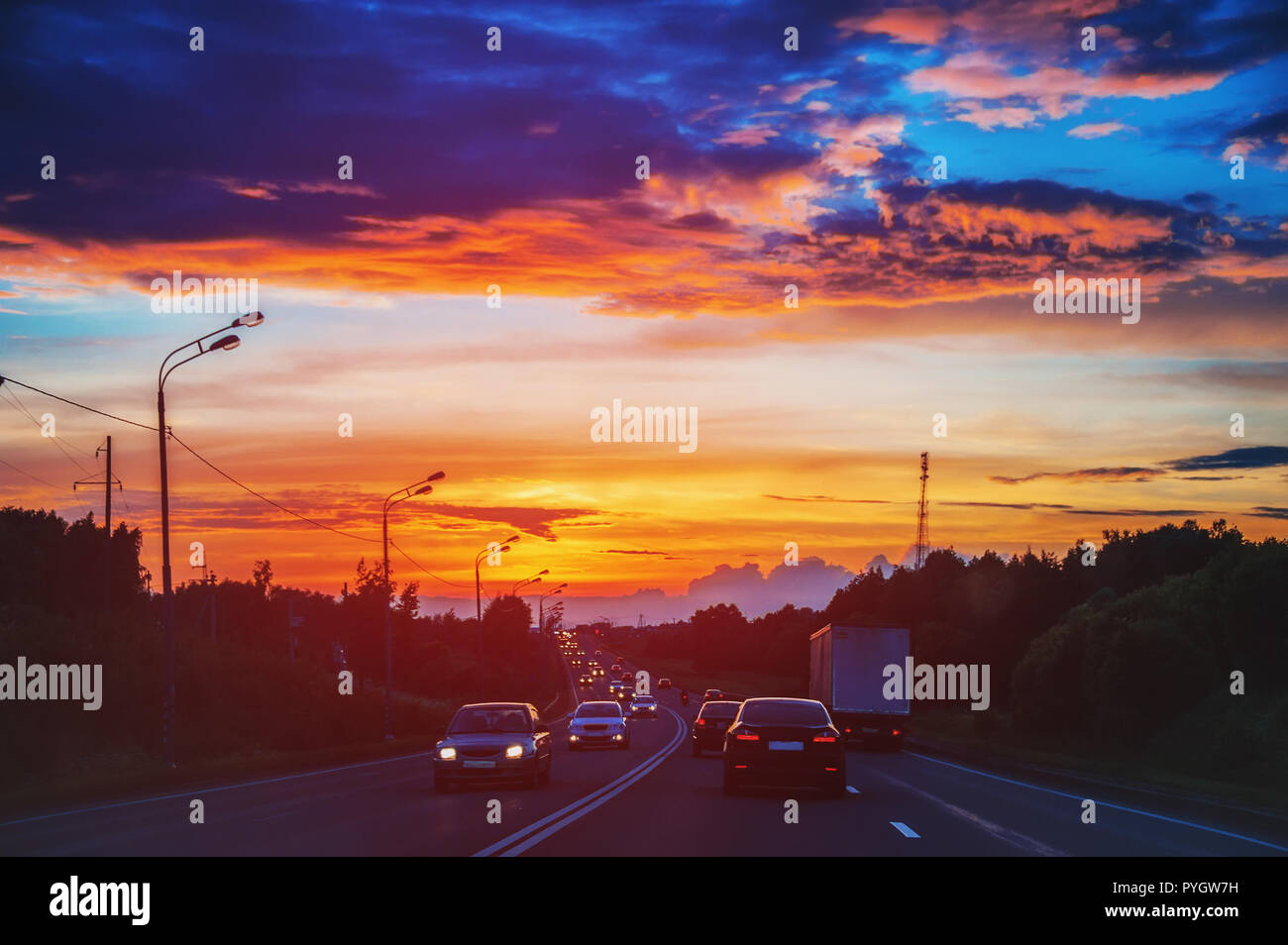 Cars ride at sunset on the road in the summer fog Stock Photo - Alamy