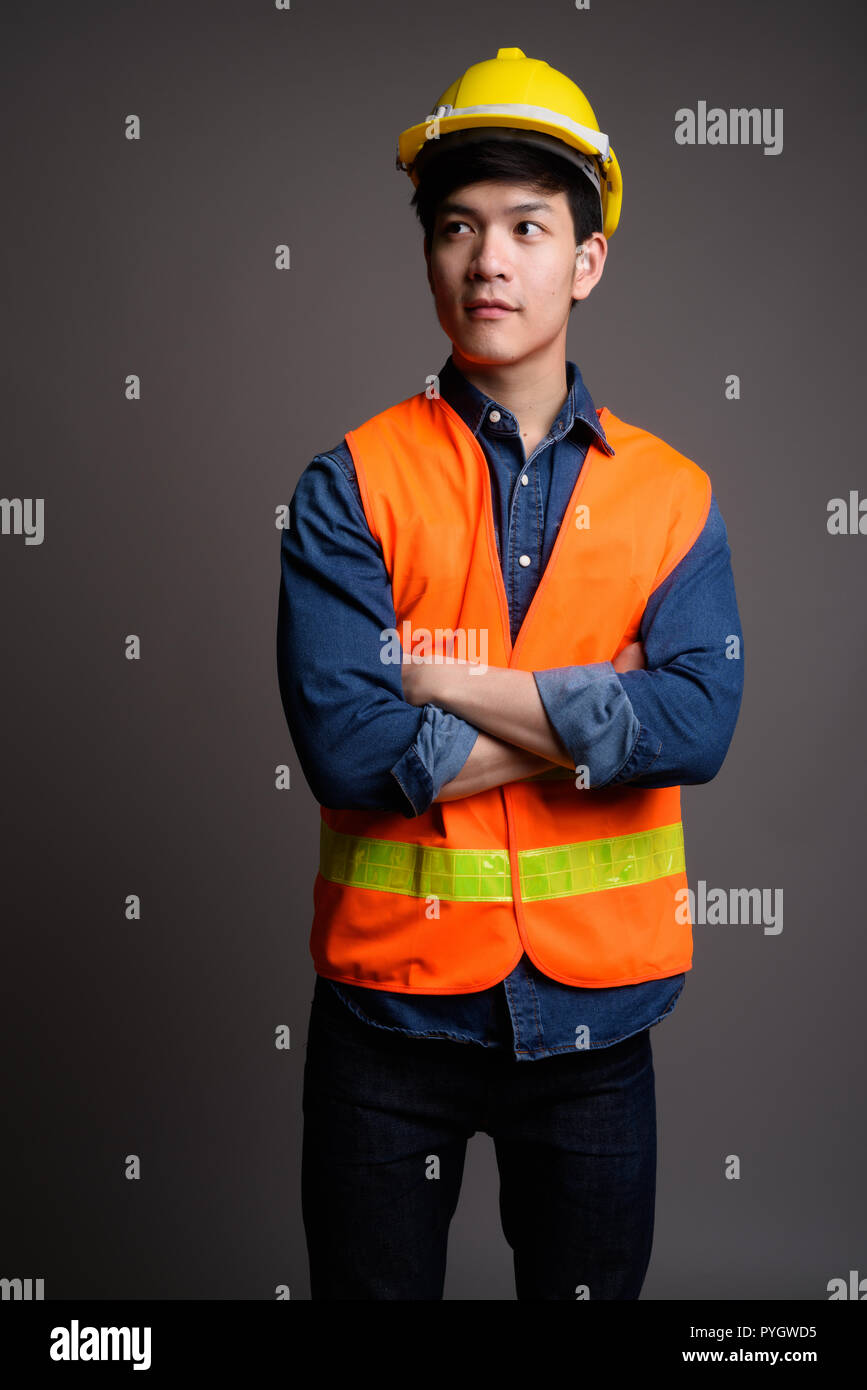 Young handsome Asian man construction worker thinking Stock Photo - Alamy