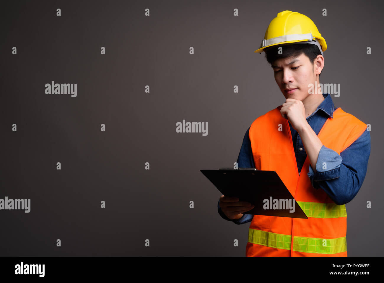 Asian man construction worker reading checklist from clipboard Stock ...