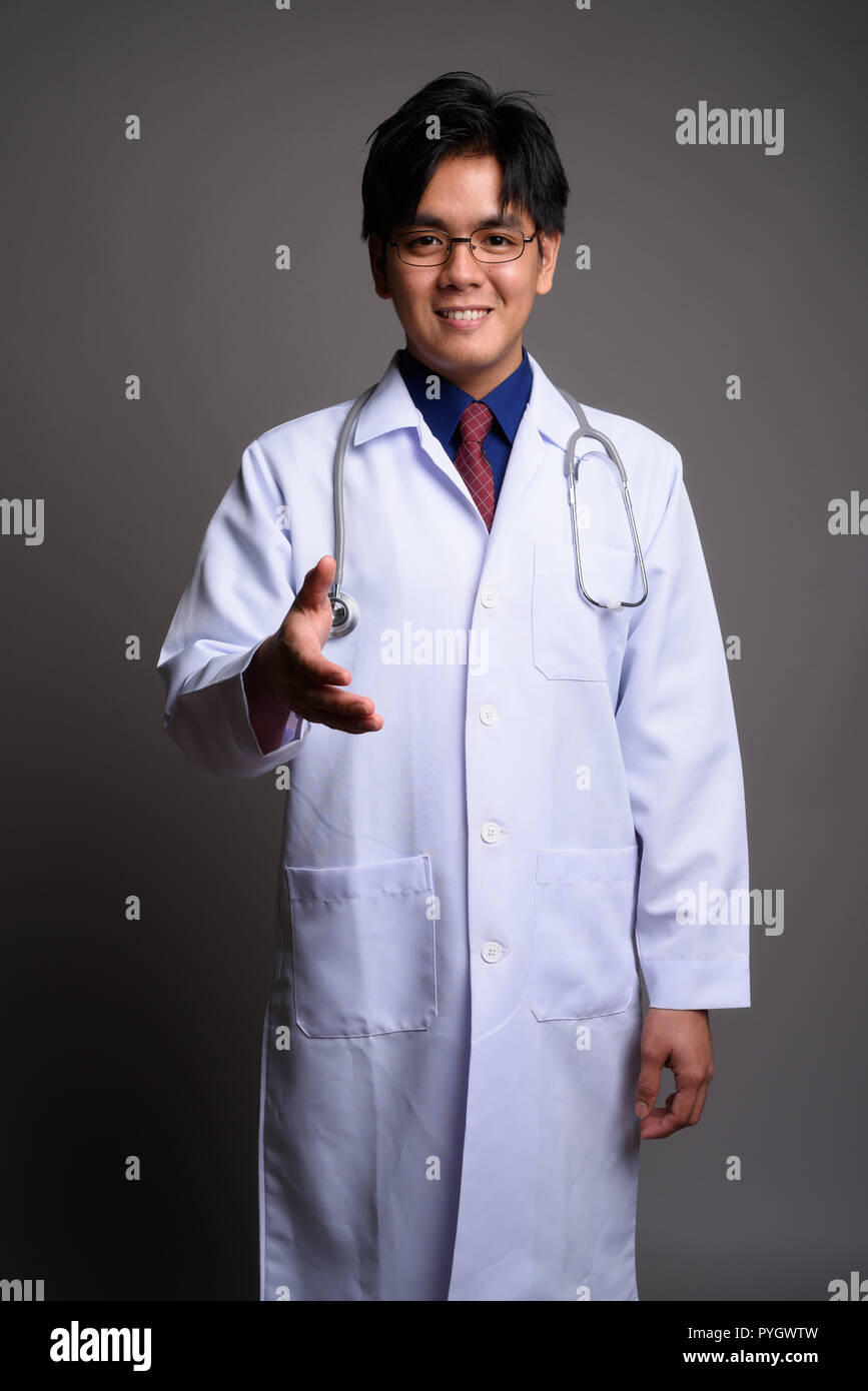 Portrait of happy young Asian man doctor giving handshake Stock Photo ...