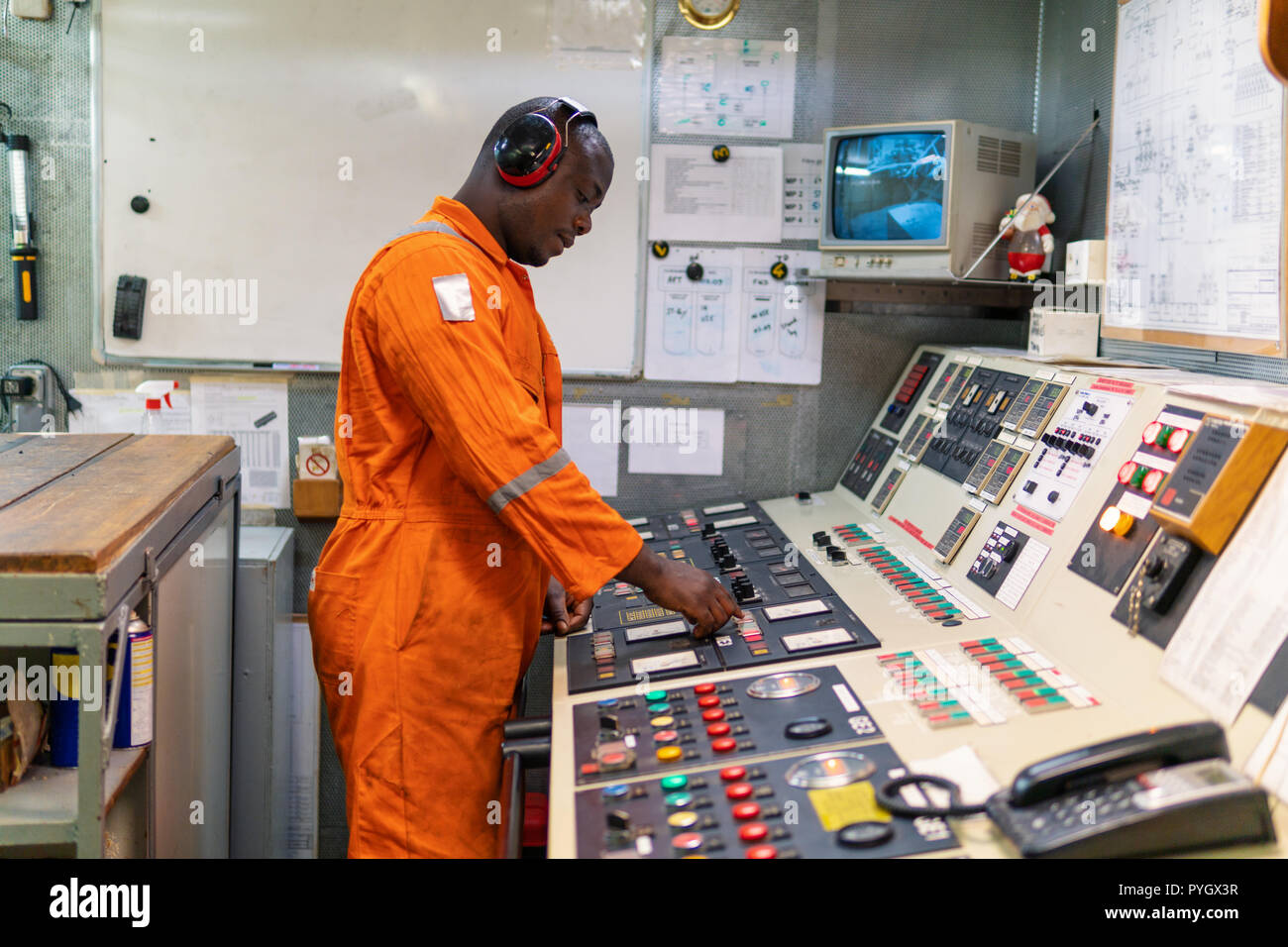 Marine engineer officer working in engine room Stock Photo - Alamy