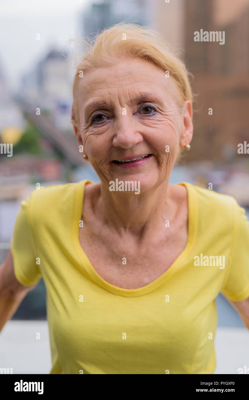 Beautiful senior woman smiling outdoors in city Stock Photo - Alamy
