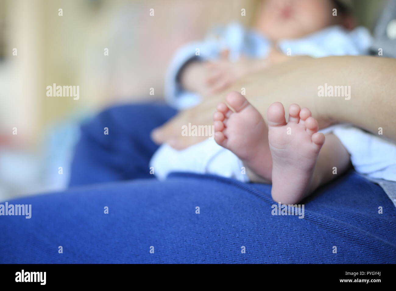 small Baby feet resting on mother leg. soft smooth skin of infant. baby ...
