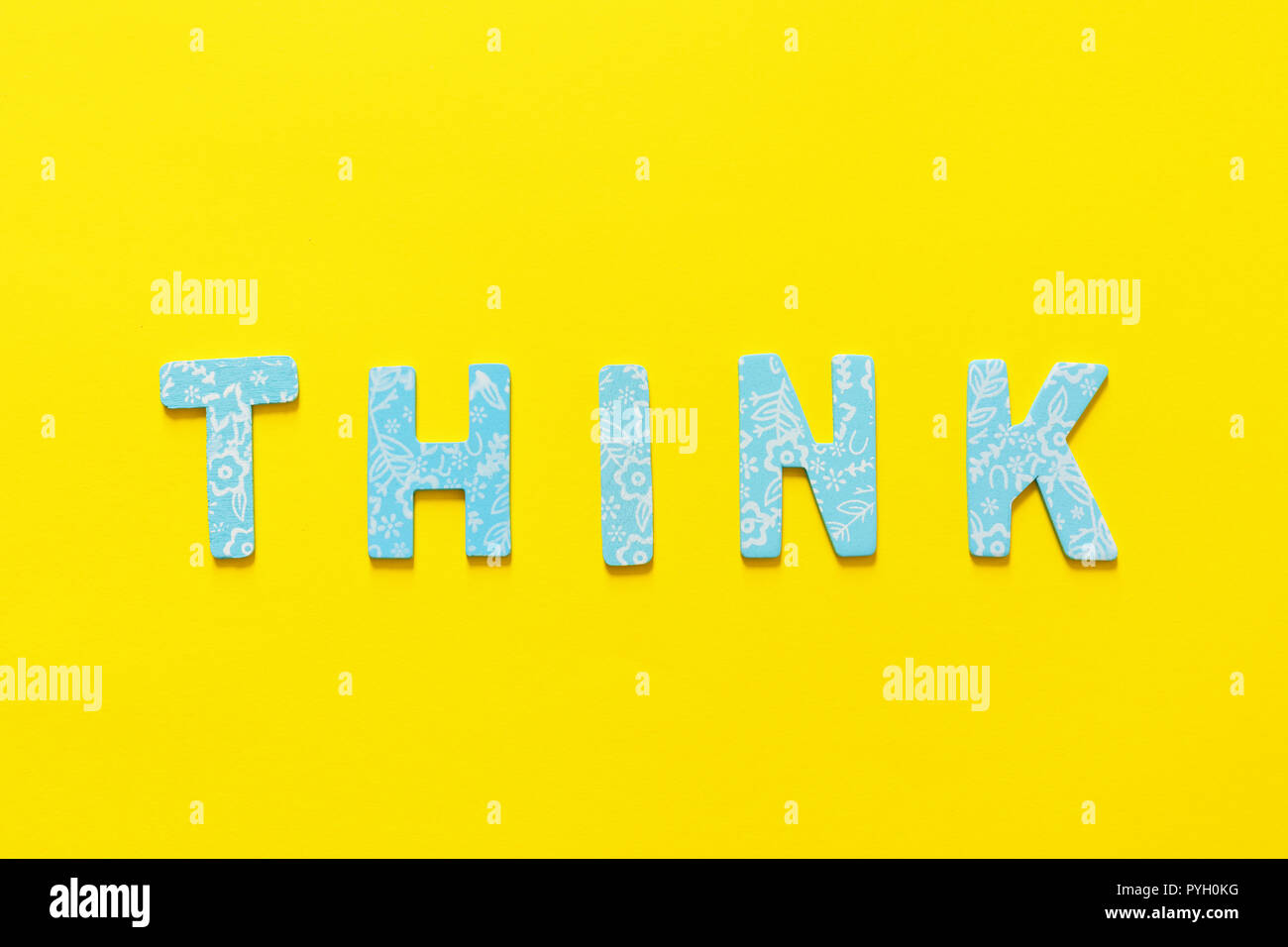 Word THINK made out of small blue letter on yellow background, flat lay ...
