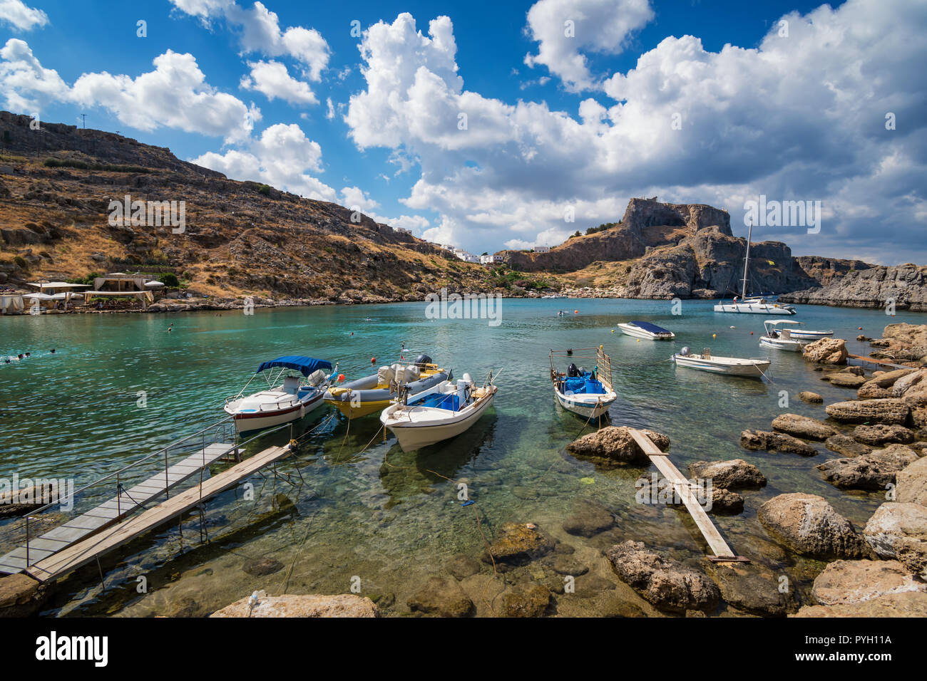 St. Paul bay with boats, Lindos acropolis in background (Rhodes, Greece ...