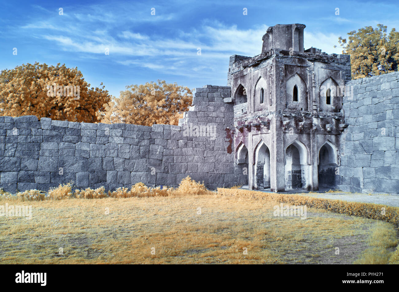 Ruins of a watch tower at the corner of a tall stone wall in Hampi ...