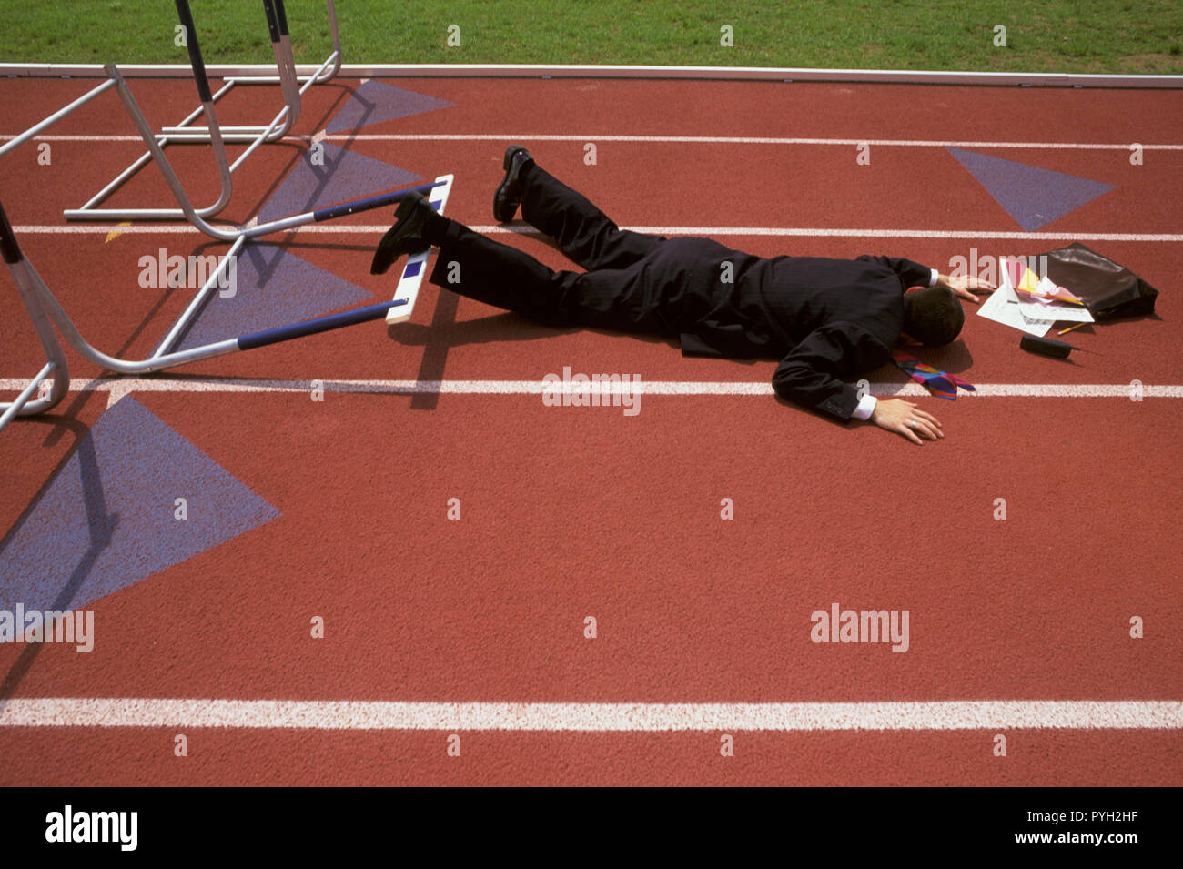 Young businessman fallen over hurdle on running track, USA Stock Photo ...