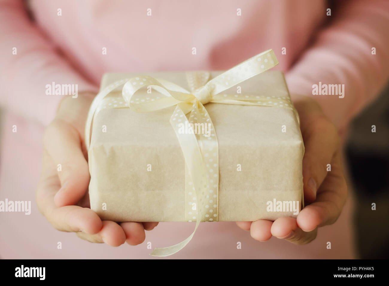 Woman hands hold gift box wrapped in paper with ribbon Stock Photo - Alamy