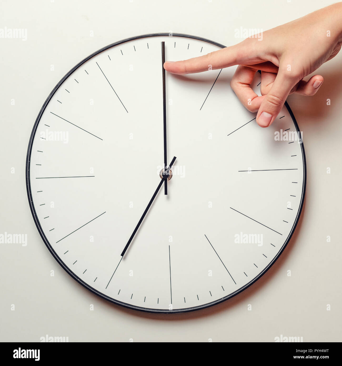 Woman hand stop time on round clock, female finger takes the minute ...