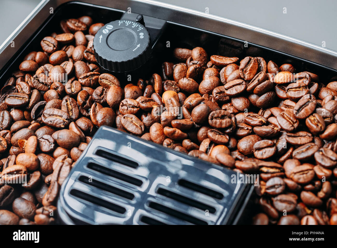 Coffee beans grinding in coffee machine grinder Stock Photo - Alamy