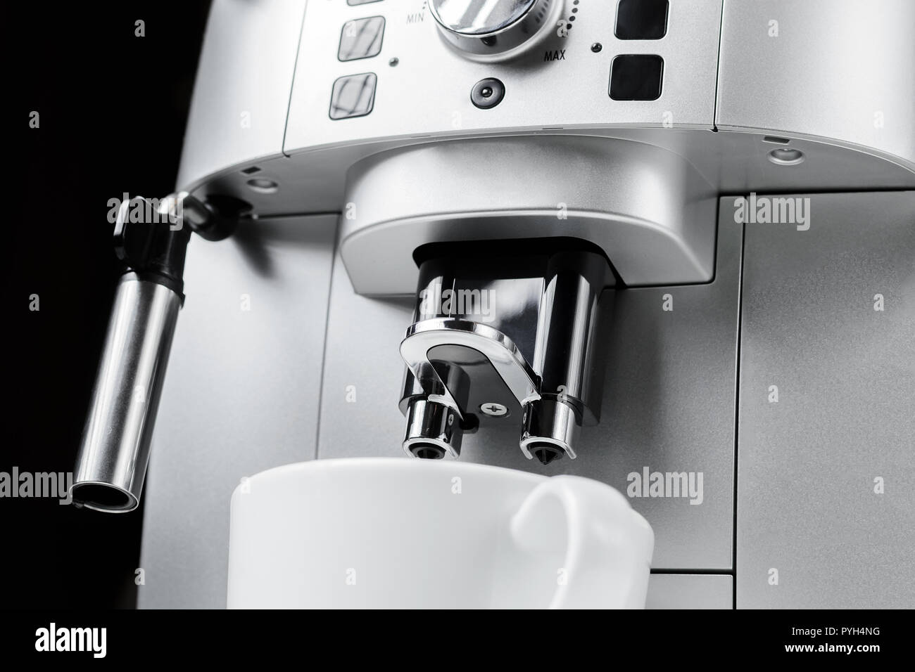 Modern coffee machine and white cup at black background, close up Stock ...