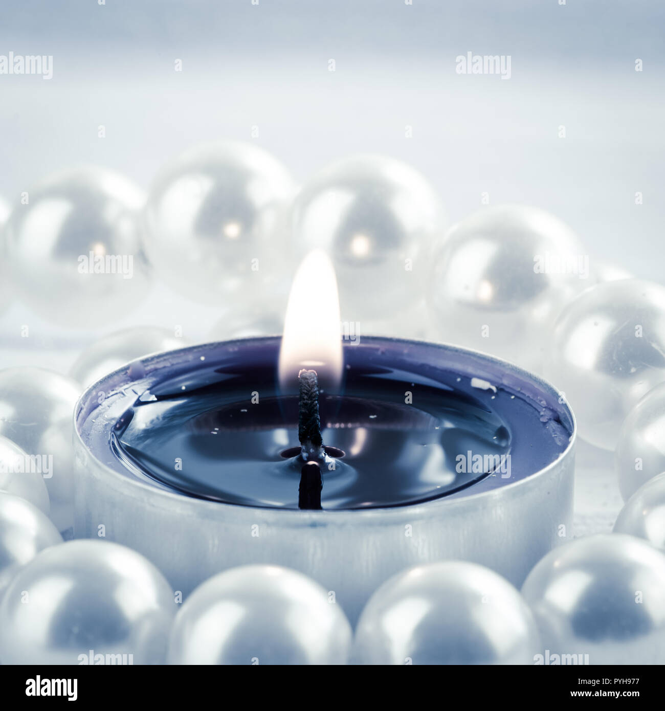 burning candle and white bead decoration Stock Photo - Alamy