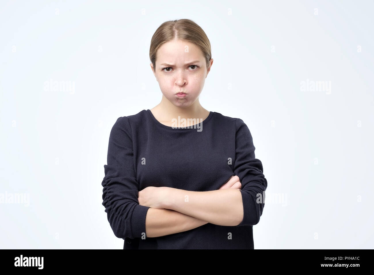 Portrait of beautiful girl frowning her face in displeasure, wearing ...