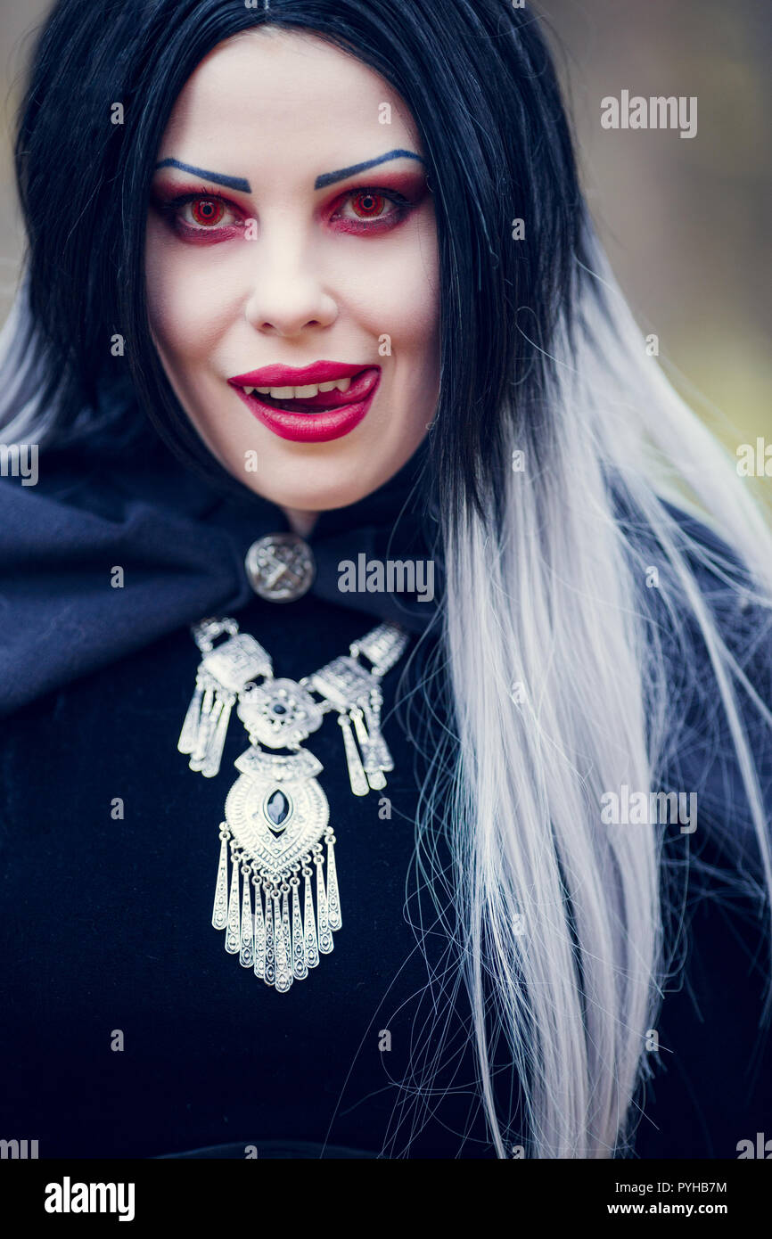 Portrait of vampire woman with long hair, red eyes Stock Photo - Alamy
