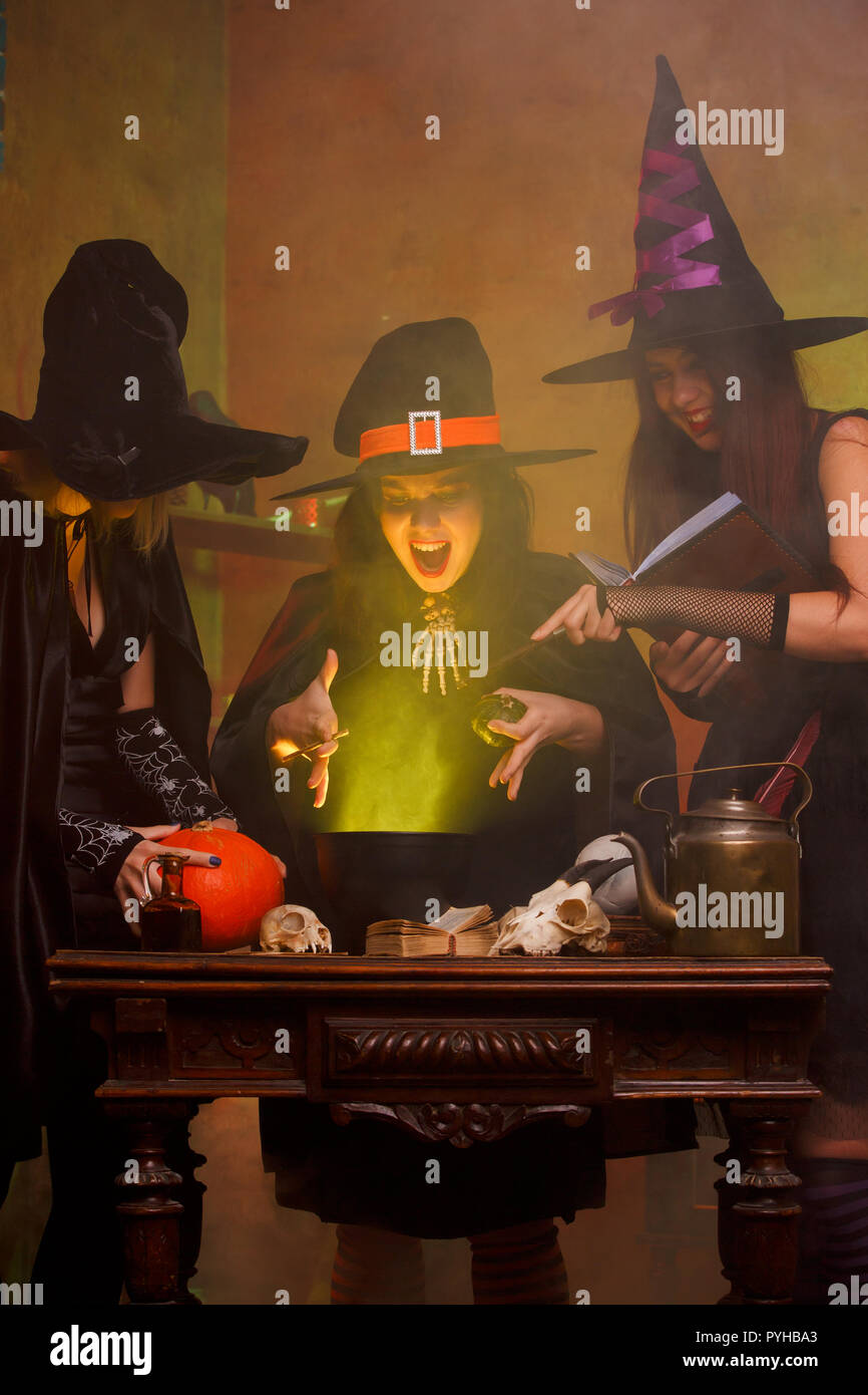 Photo of three witches boiling potion in cauldron Stock Photo - Alamy