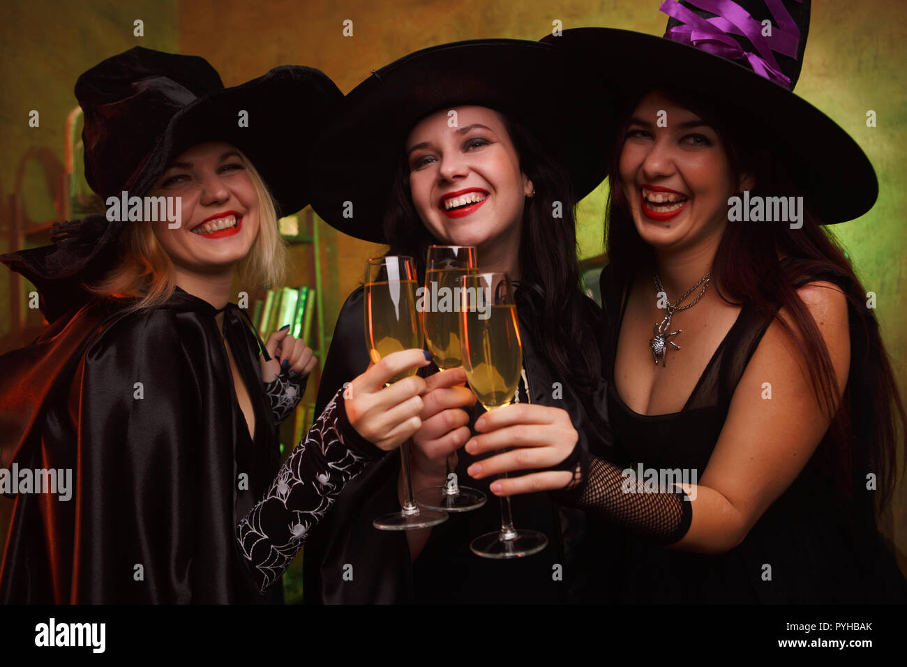 Portrait of three happy witches with glass of champagne Stock Photo - Alamy