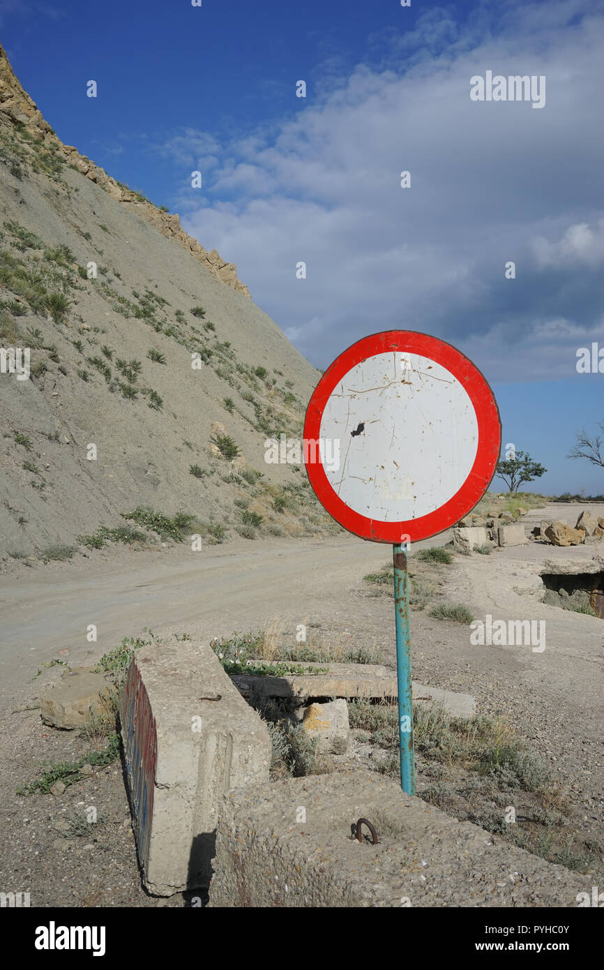 A road sign on the background of the old dilapidated and dusty roads ...