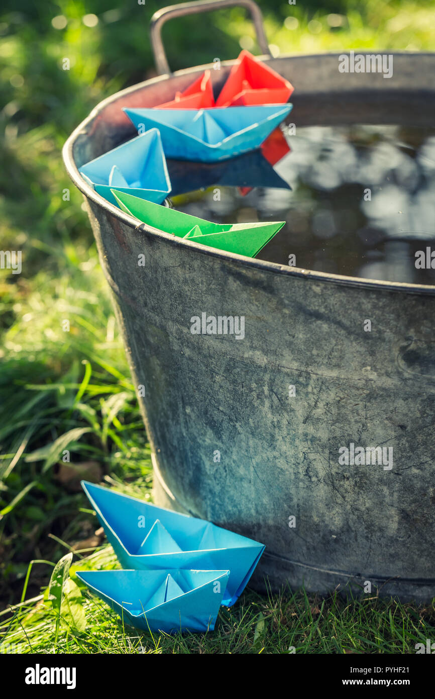 Small paper boats floating on water in washtube Stock Photo - Alamy
