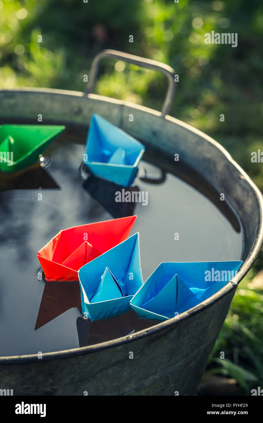 Origami paper boats quietly floating on water in garden Stock Photo - Alamy