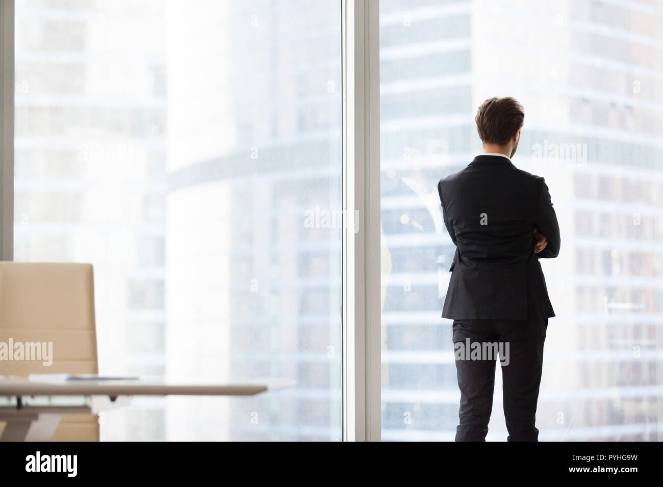 Back view portrait of successful businessman standing by window Stock ...