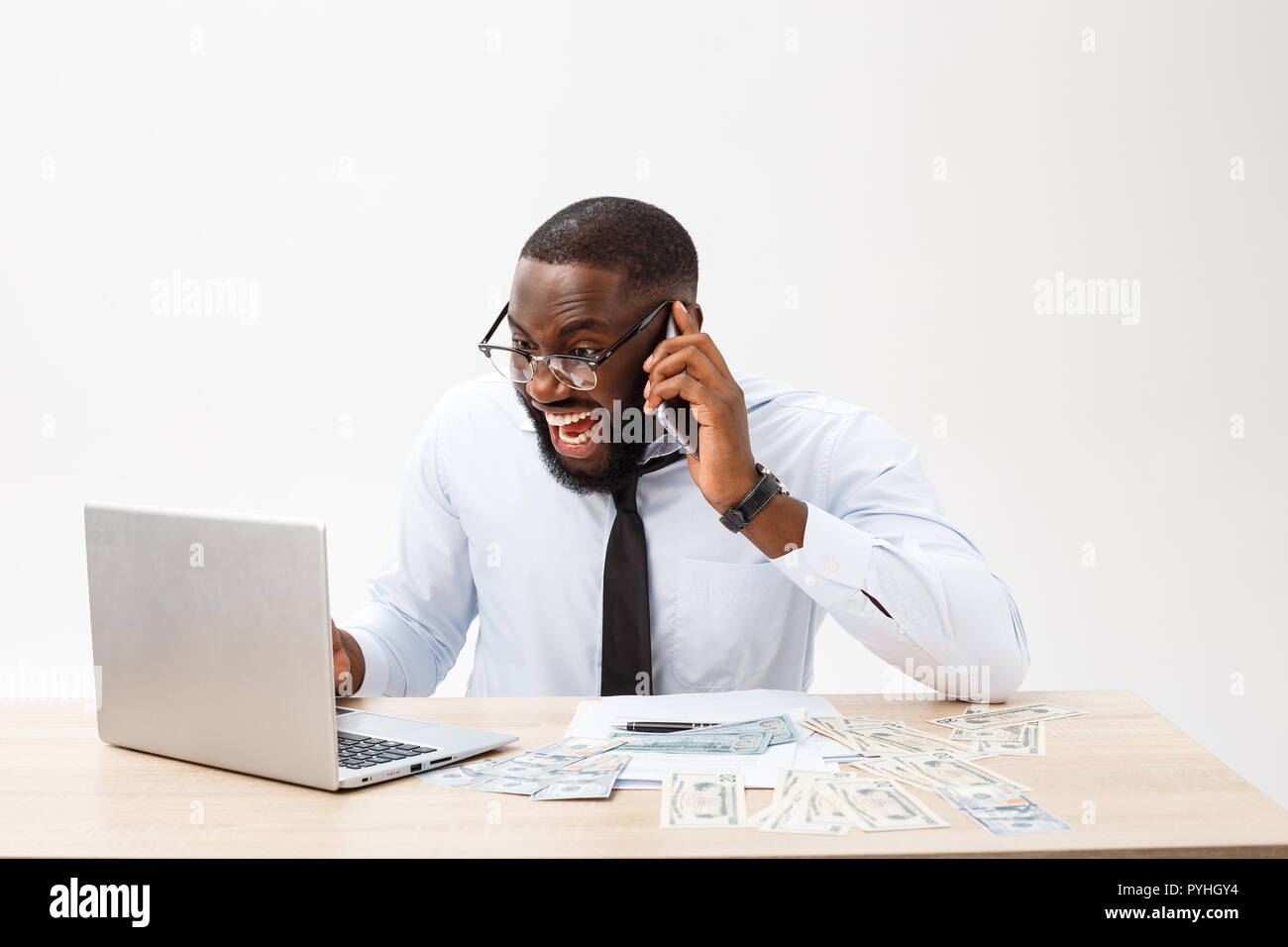 Focused African-American office manager sitting at office with laptop ...