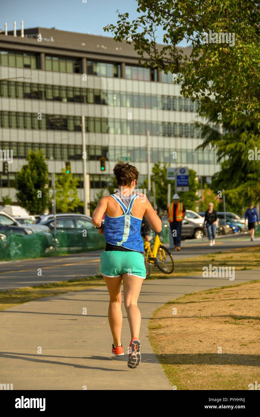 SEATTLE, WASHINGTON STATE, USA - JUNE 2018: Female running along a city ...