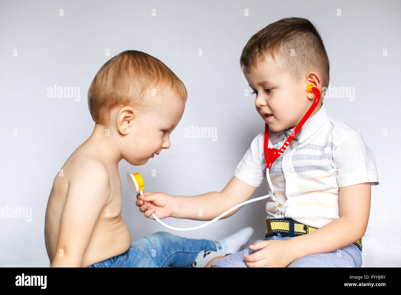 Two little boys using stethoscope. Children playing doctor and patient ...