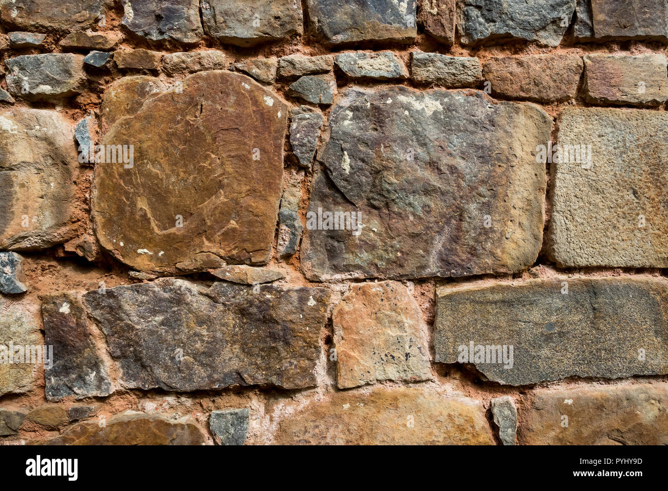 Background rock wall. A fragment of the old wall made of stones of ...