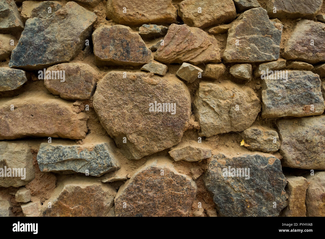 Background rock wall. A fragment of the old wall made of stones of ...