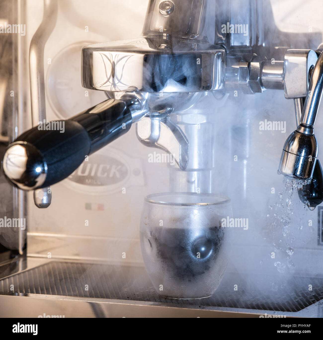 Dramatic photo of an espresso machine producing steam and water vapor ...