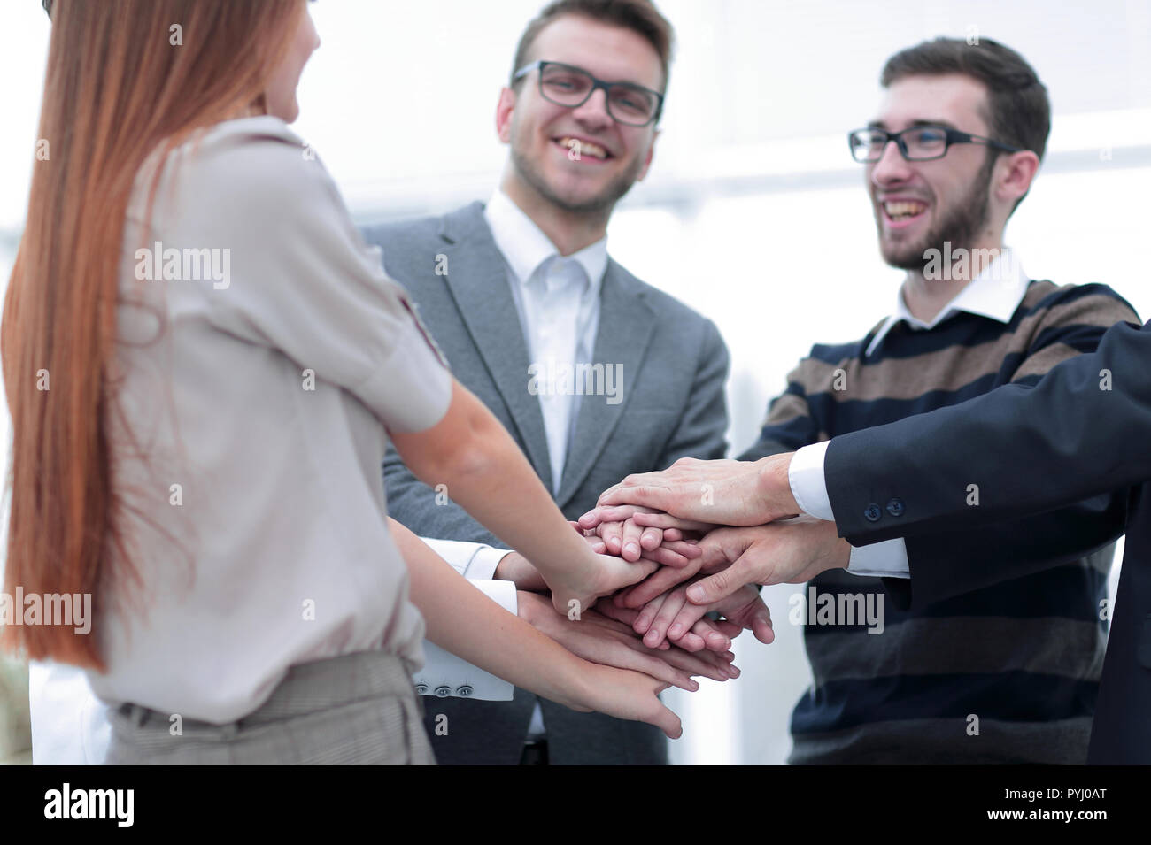 Business team standing joining hands together Stock Photo - Alamy