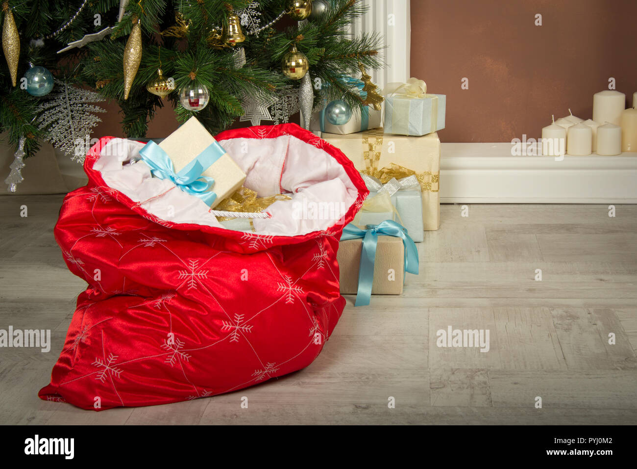 Red sack with gifts under the Christmas tree Stock Photo - Alamy
