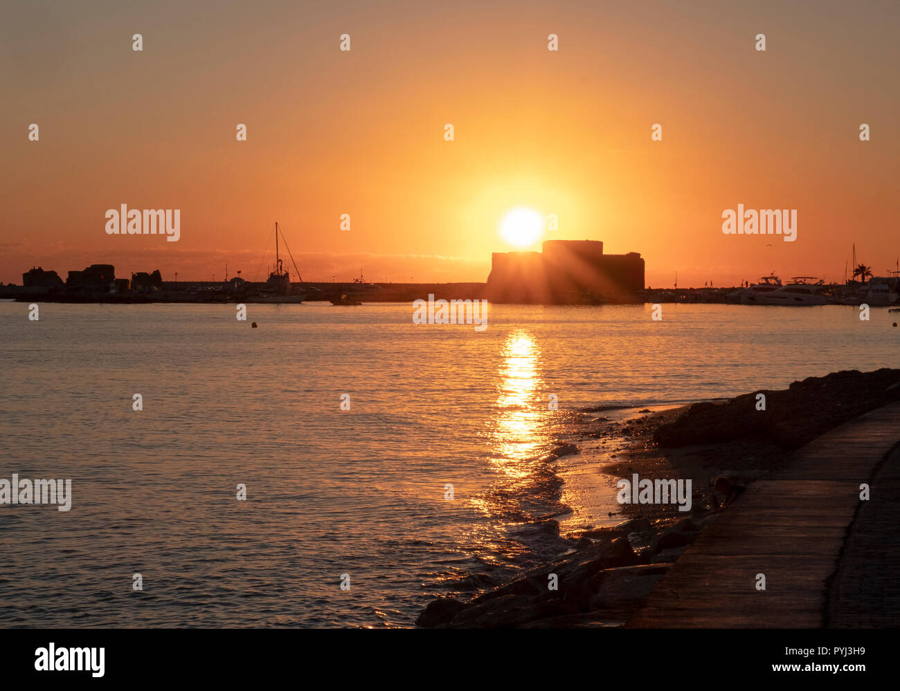 The sun sets behind Paphos Castle in Paphos, Cyprus Stock Photo - Alamy