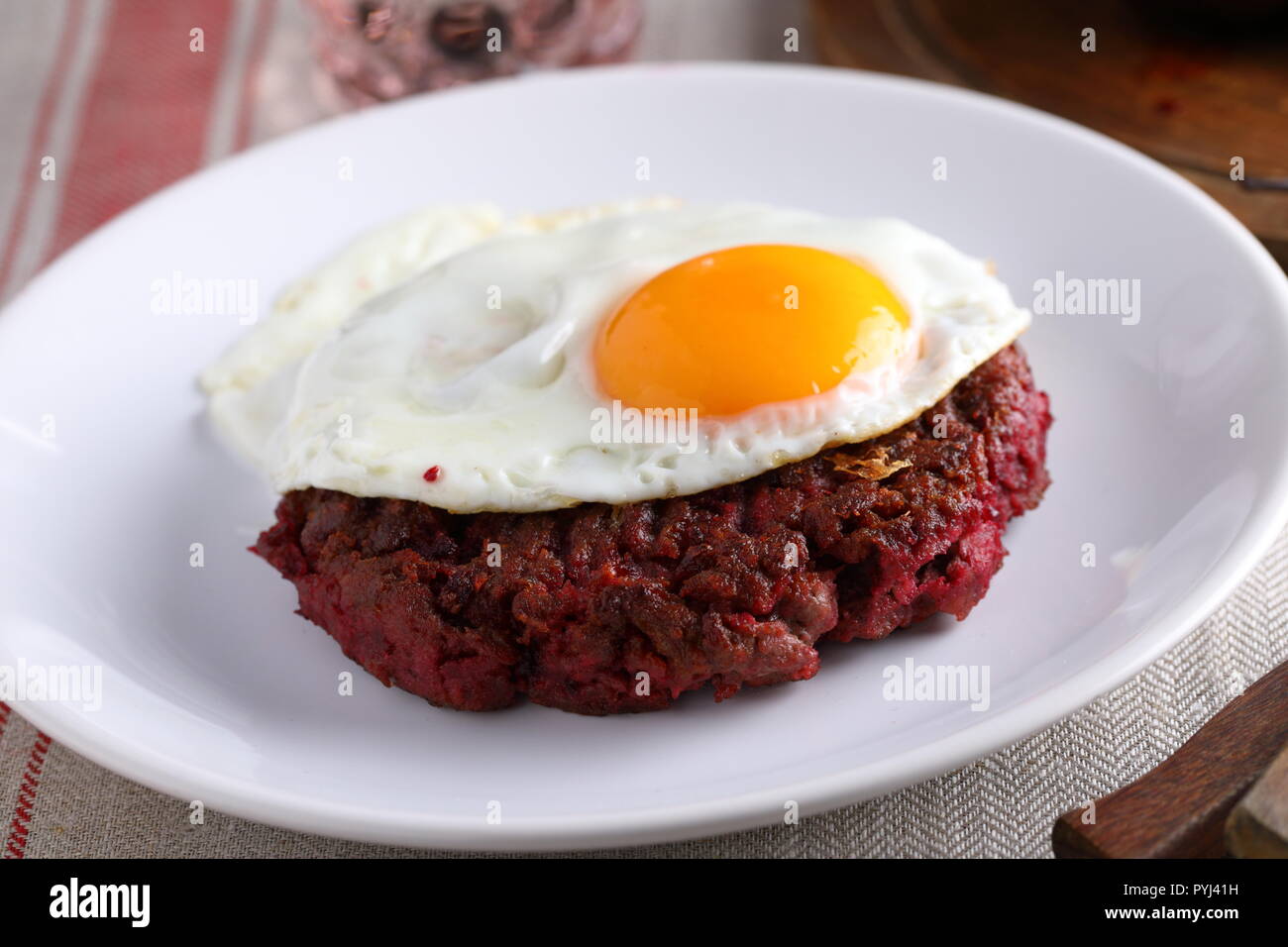 Swedish beef burger Biff a la Lindstrom with fried egg Stock Photo - Alamy