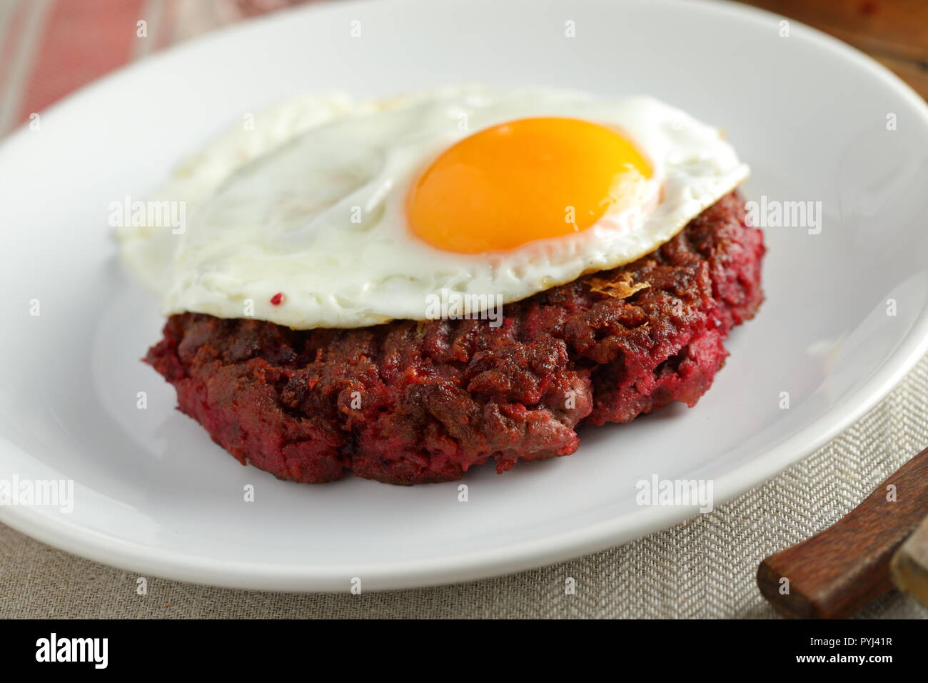 Swedish beef burger Biff a la Lindstrom with fried egg Stock Photo - Alamy