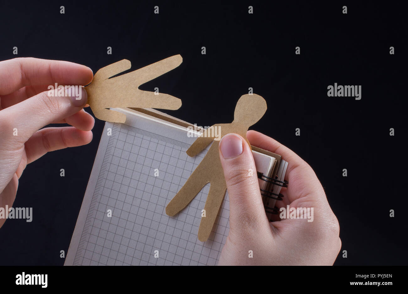 Men shape cut out of paper in notebbok in hand Stock Photo - Alamy