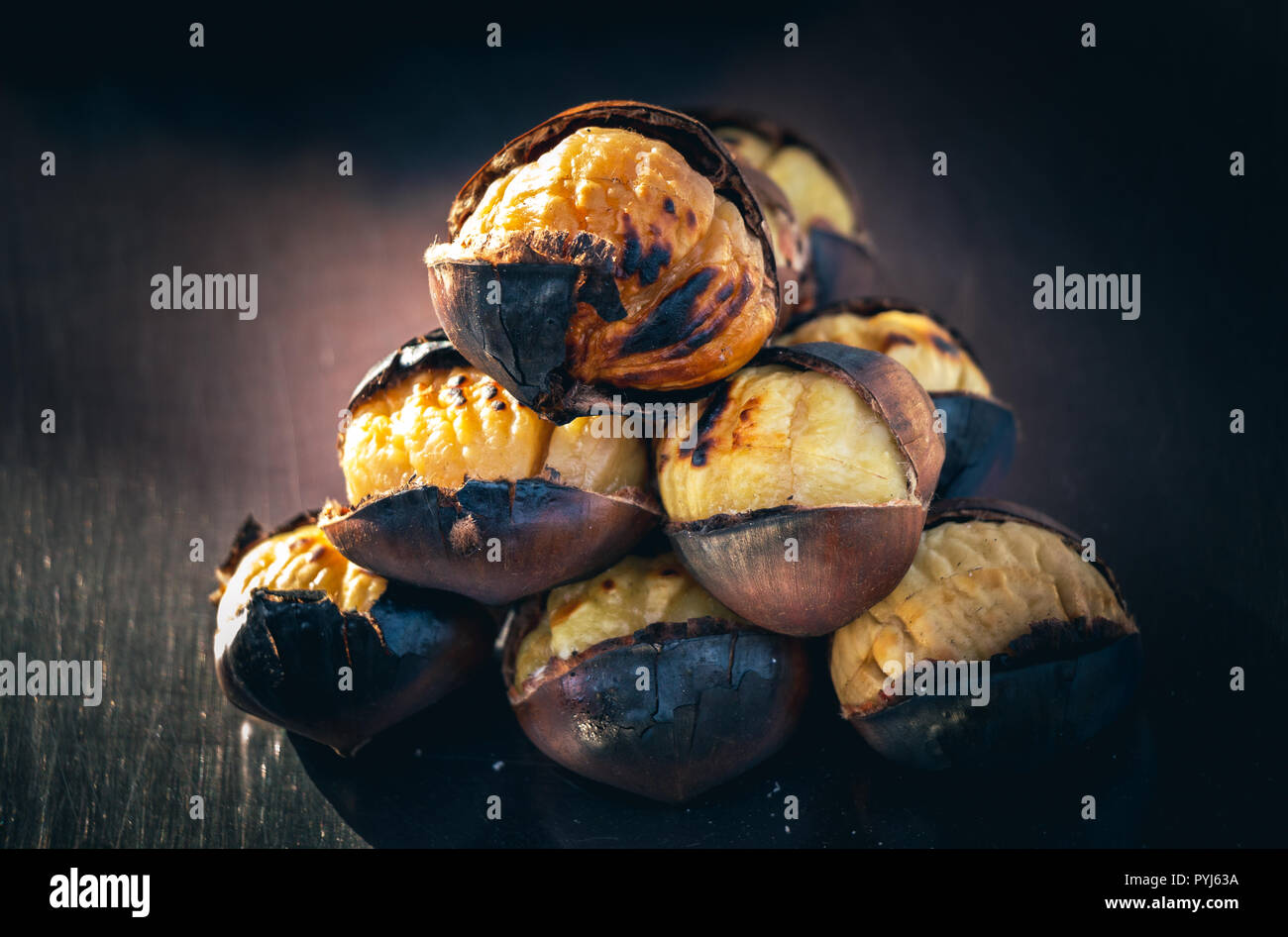 Organic brown chestnuts roasted over a hot fire Stock Photo - Alamy